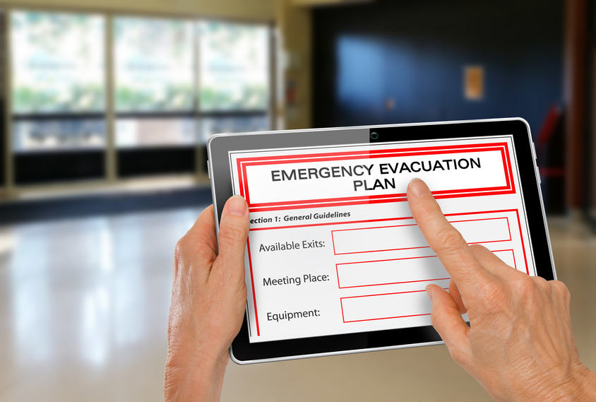 Hands with Computer Tablet and Emergency Evacuation Plan - Compliance ...